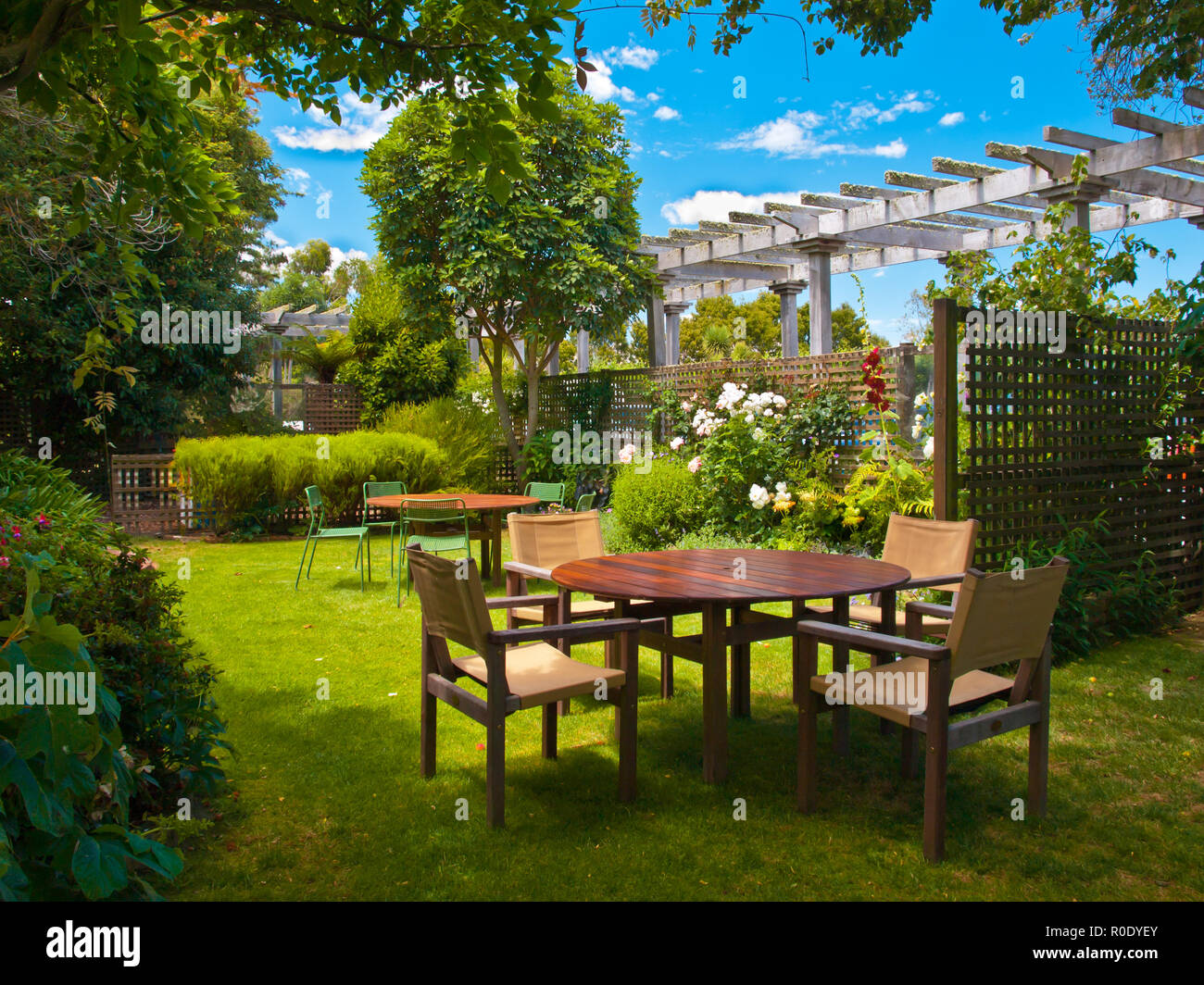Landscaped Garden with Wooden Dining Table Set in the Shade of Trees ...