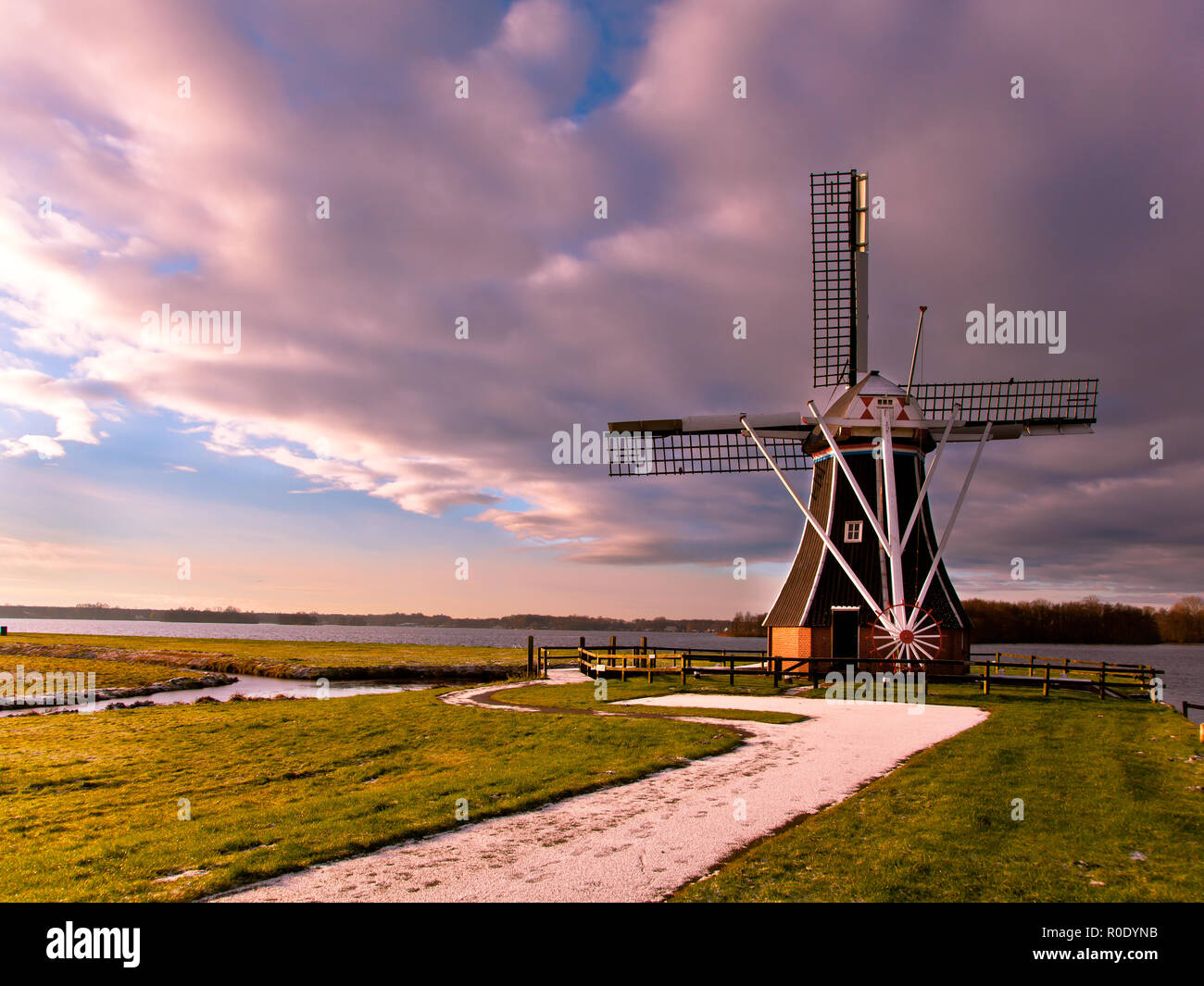 Dutch Windmill on the Waterfront of a Lake with Spectacular Clouds ...