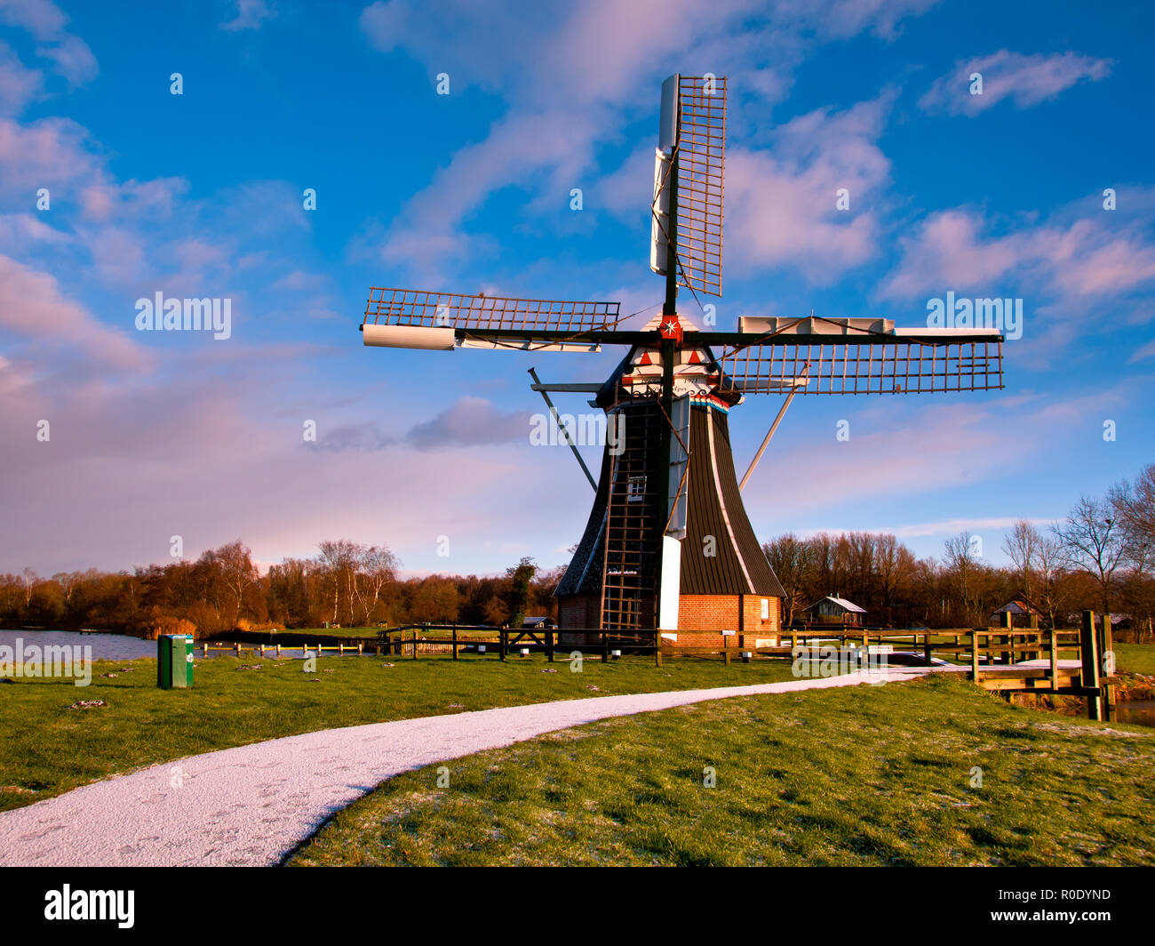Dutch Windmill on the Waterfront of a Lake with Spectacular Clouds ...