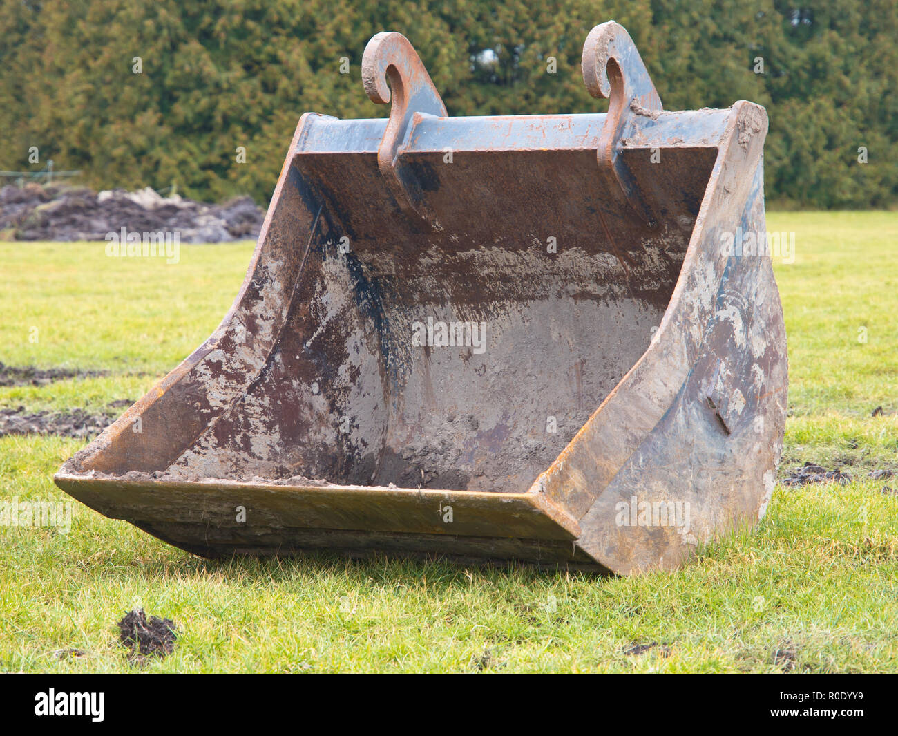 Excavator bucket in a field of grass Stock Photo - Alamy