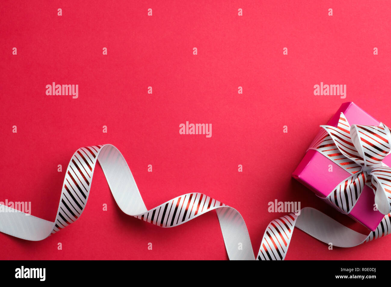 Red gift box with stripe ribbon Stock Photo - Alamy