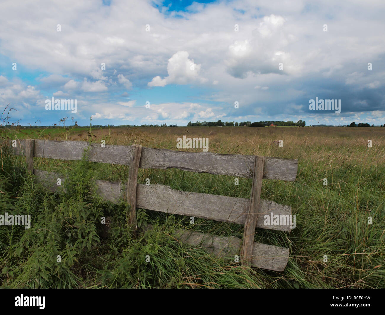 Fence in nature reserve with clouded summer sky Stock Photo - Alamy