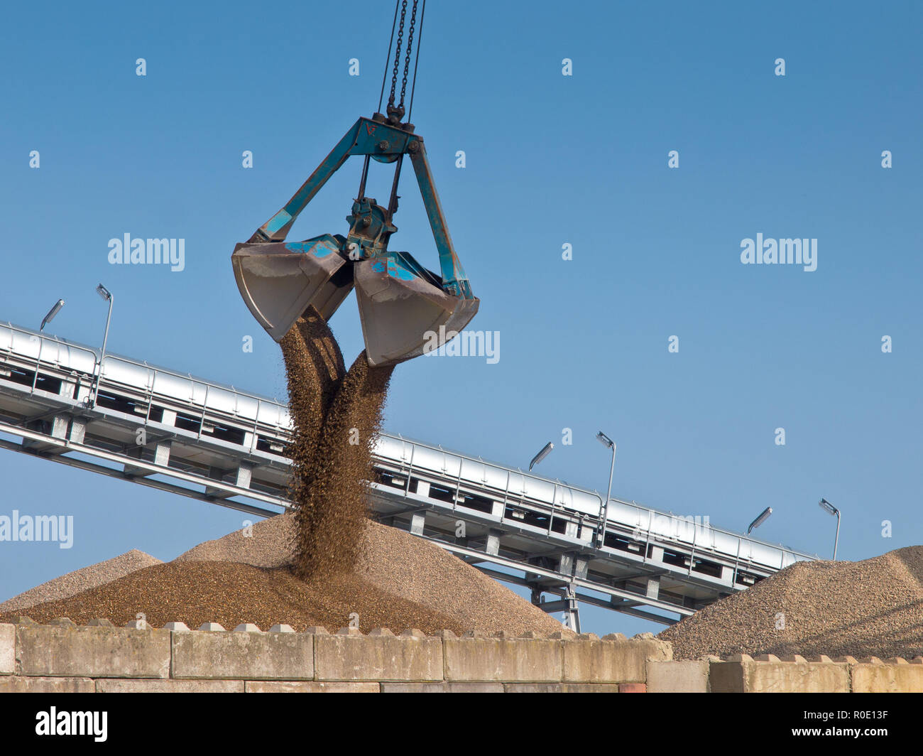Excavator is releasing a scoop of sand in a silo Stock Photo - Alamy