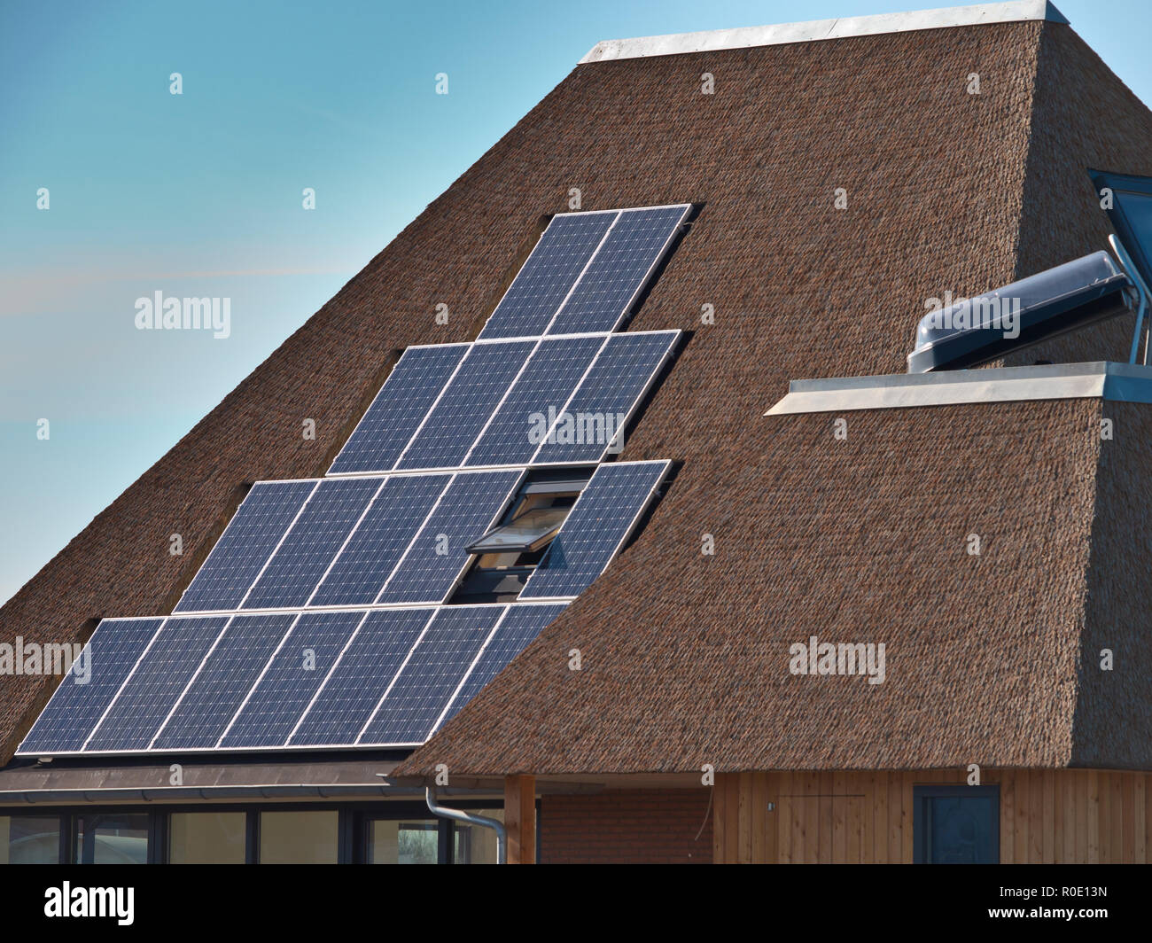 Solar panels on a modern house with thatched roof Stock Photo - Alamy