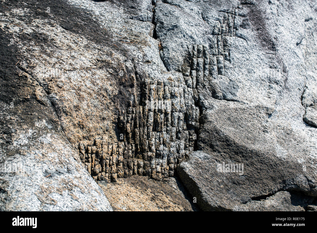 Grey rocky surface with distinct vertical patterns in the middle, can ...