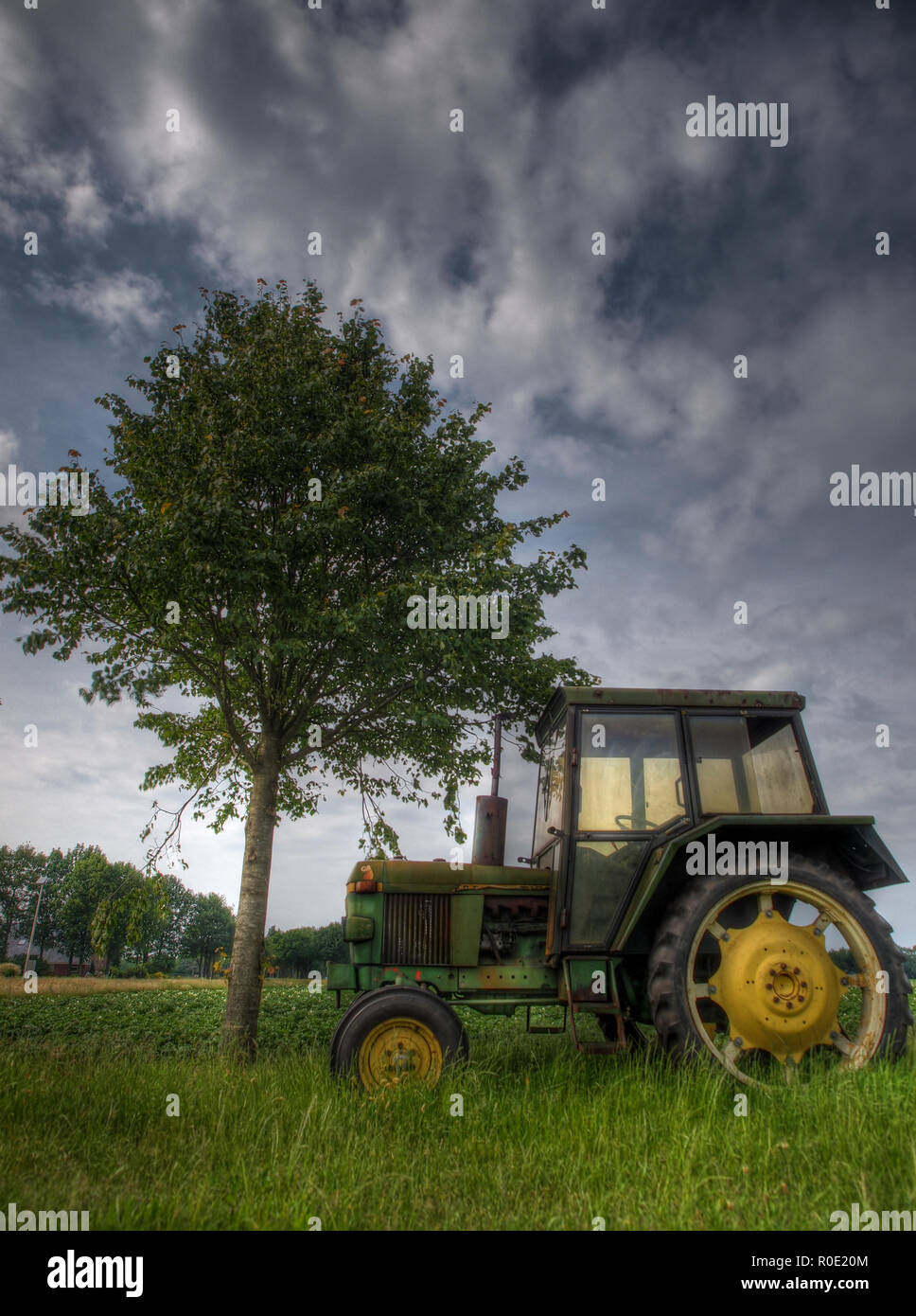 lonely tractor with tree portrait Stock Photo - Alamy