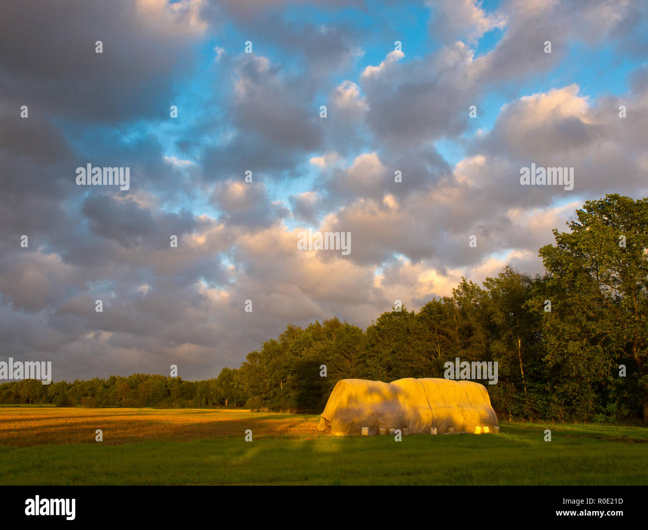 hay stack during sunset with dramatic cloudy sky Stock Photo - Alamy