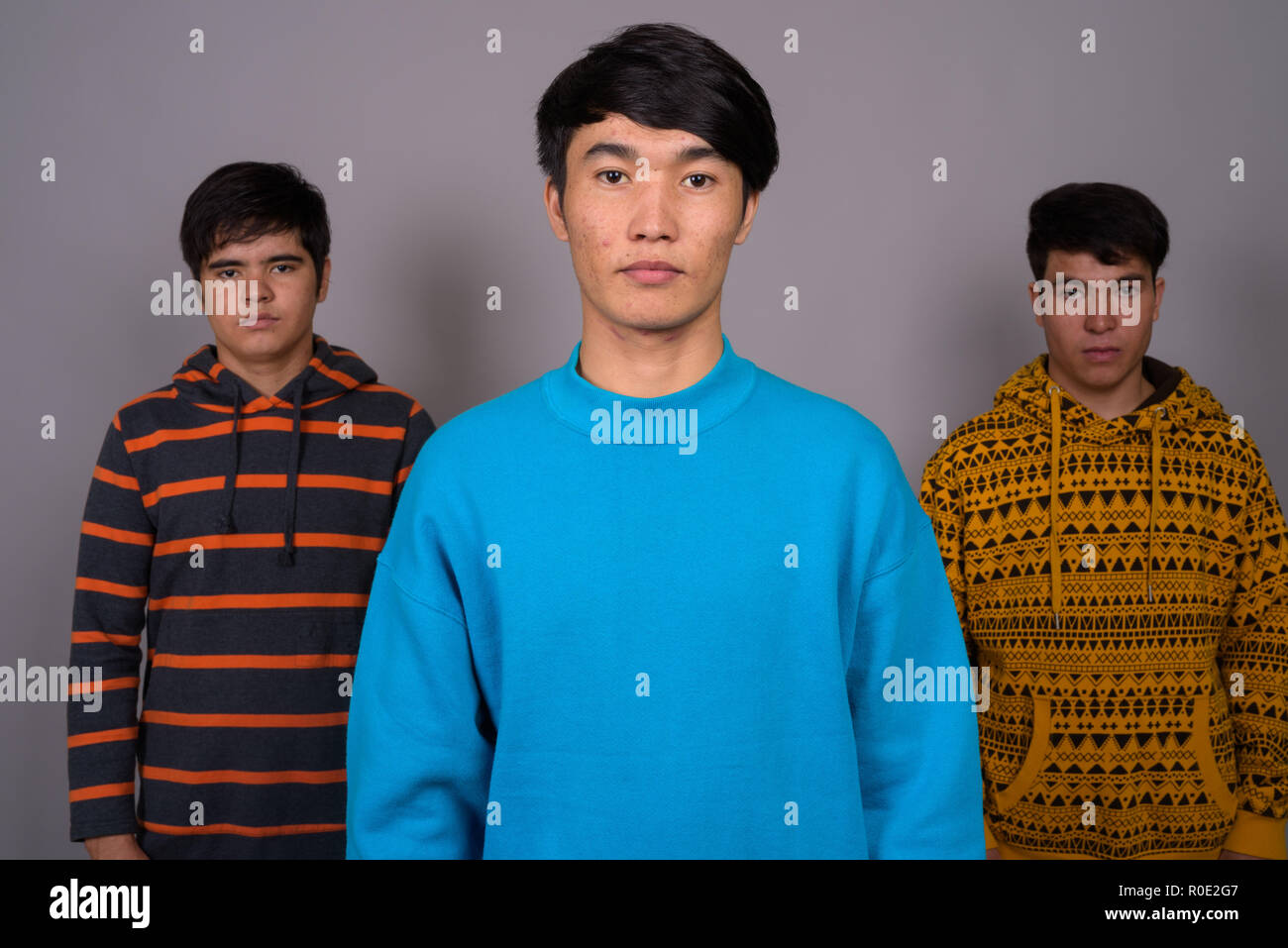 Three young Asian friends together against gray background Stock Photo ...