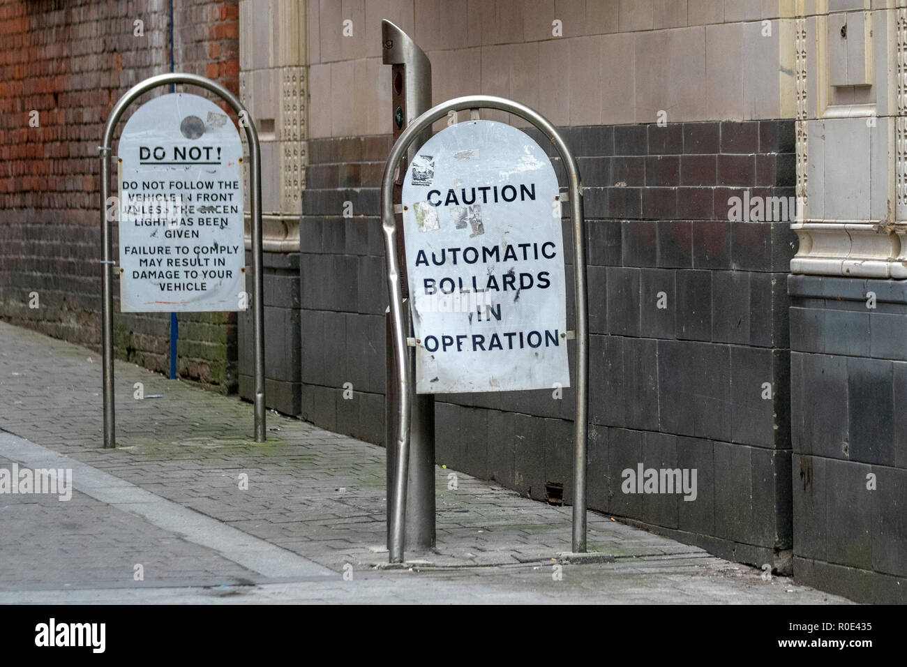Bent, broken, Automatic Bollards in operation; a street sign in ...