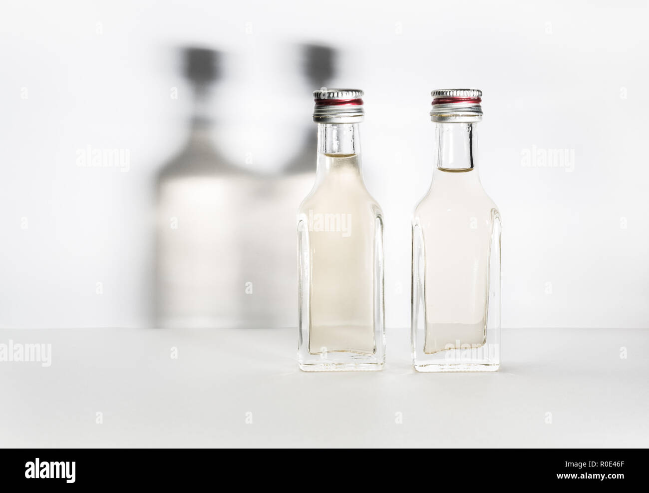 Two bottles of vintage alcohol with shadows on the wall Stock Photo - Alamy
