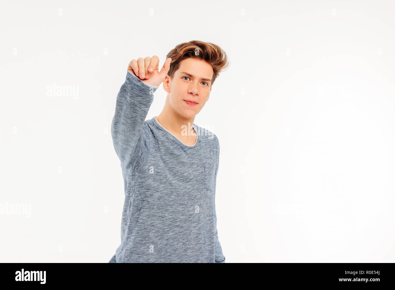 Smiling young guy welcomes saying goodbye to hand on white background ...