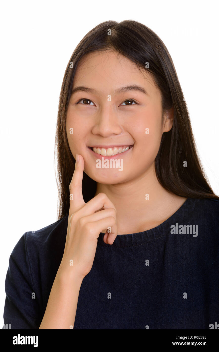 Young happy Asian teenage girl smiling and thinking Stock Photo - Alamy