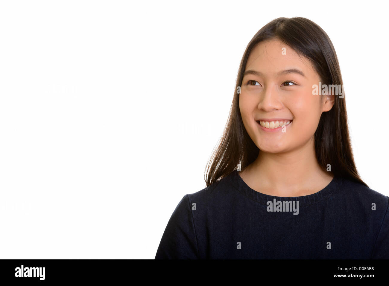 Young happy Asian teenage girl smiling and thinking Stock Photo - Alamy