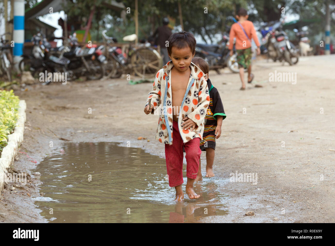 MANDALAY,MYANMAR,JANUARY 19, 2015 : A little boy is playing with his friend in the street ...