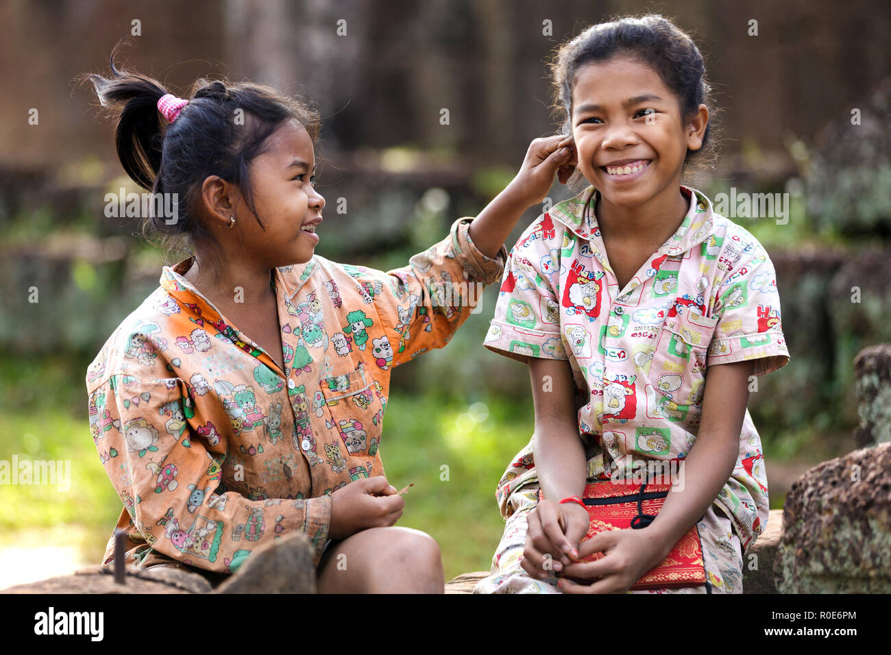 SIEM REAP, CAMBODIA, DECEMBER 04, 2012 : Little girl pinching the ear ...