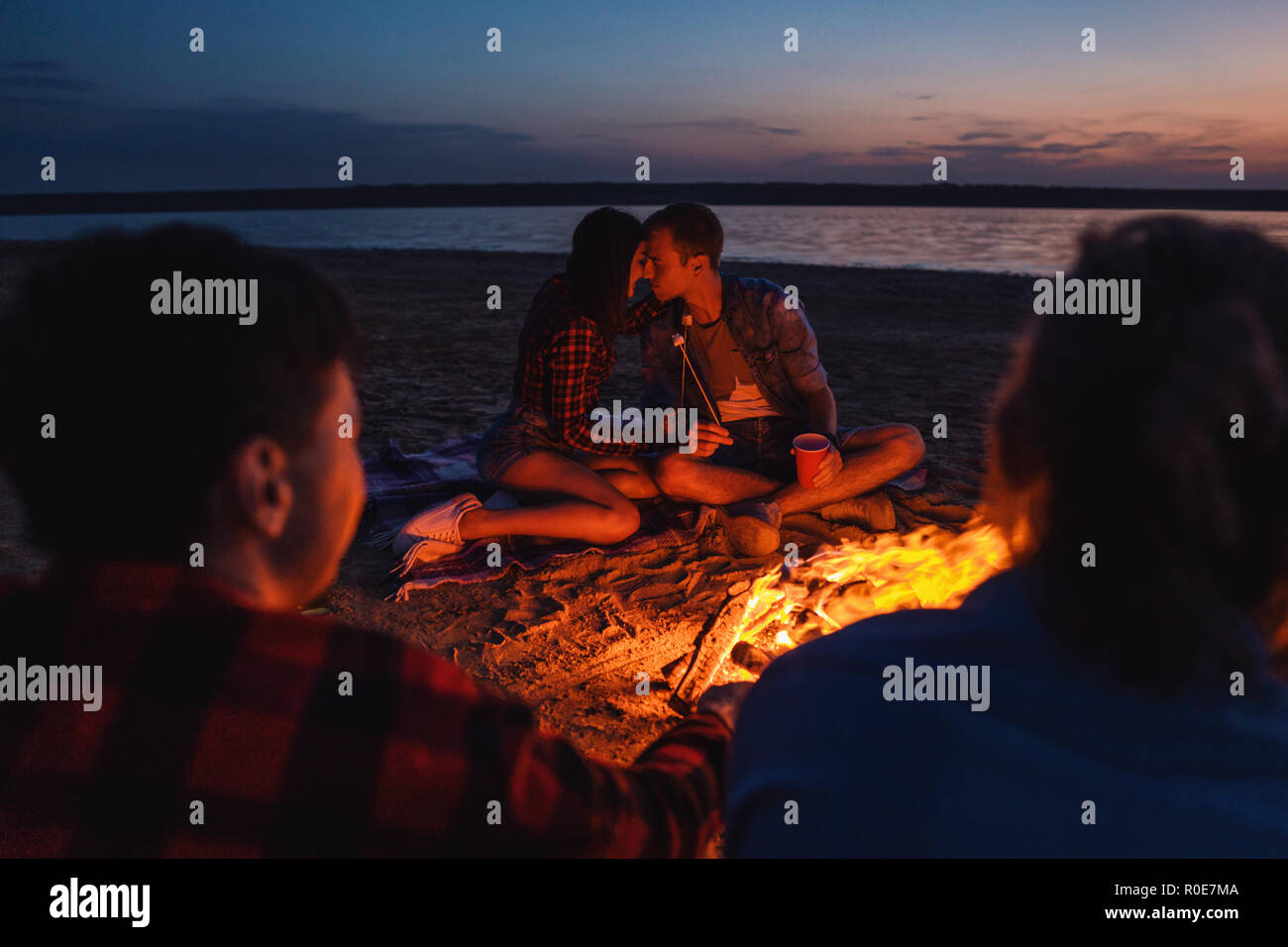 young friends have picnic with bonfire on the beach Stock Photo - Alamy