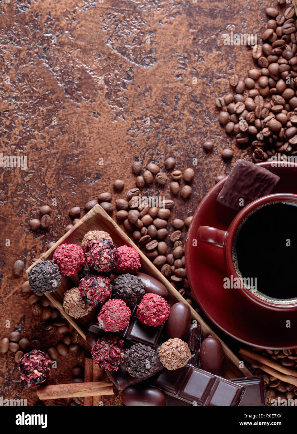 Various chocolates and cup of black coffee. Sweets with cinnamon sticks ...