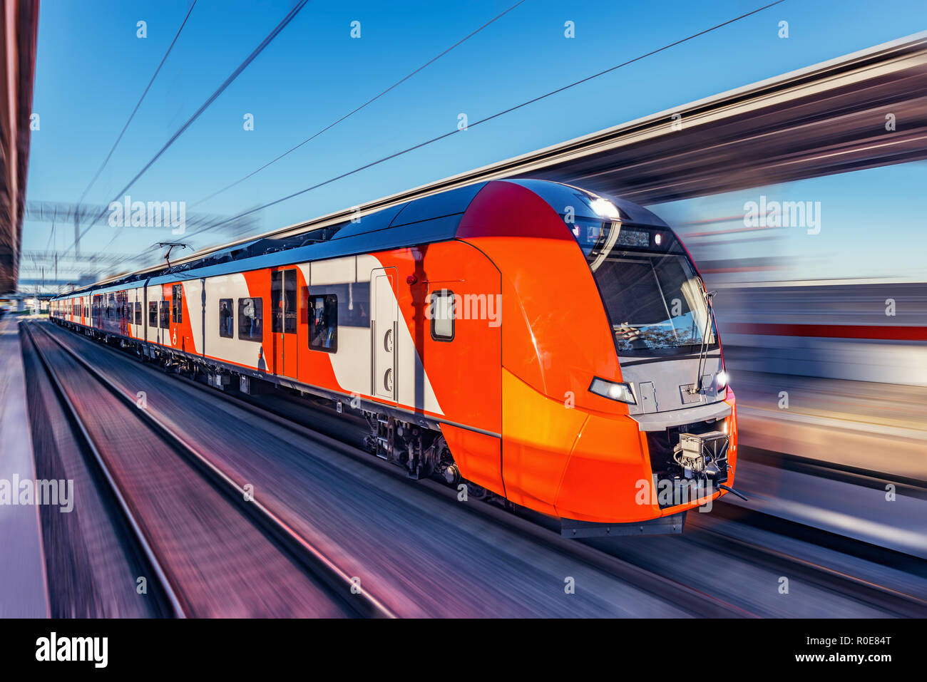 Modern high-speed train moves fast along the platform Stock Photo - Alamy