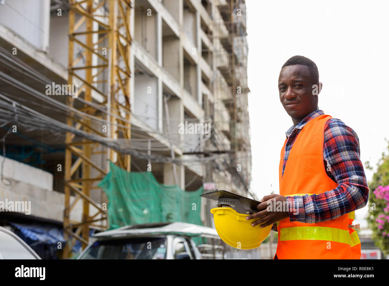 Young black African man construction worker holding clipboard an Stock ...