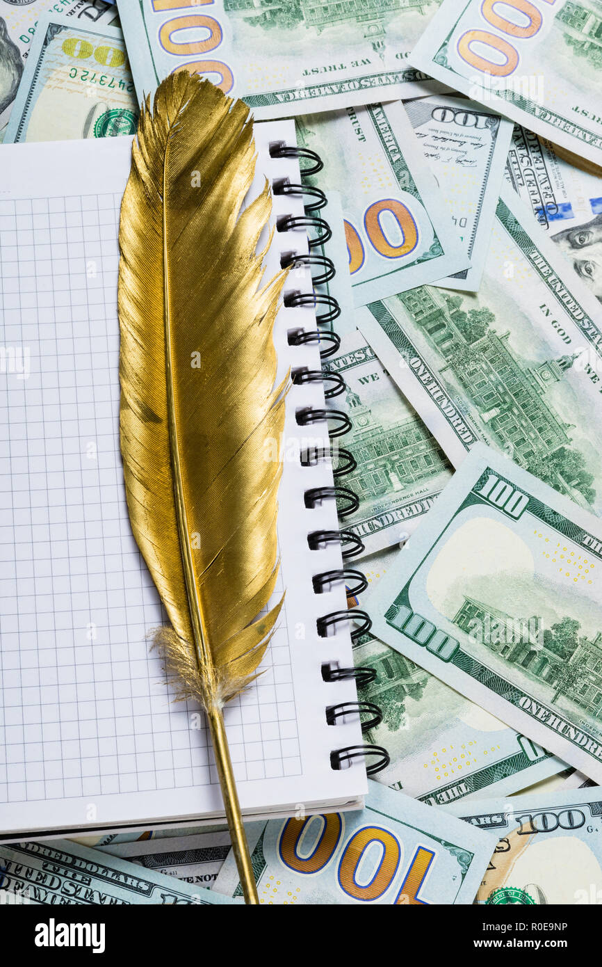 Notebook and Gold quill pen on dollar money background from one hundred ...
