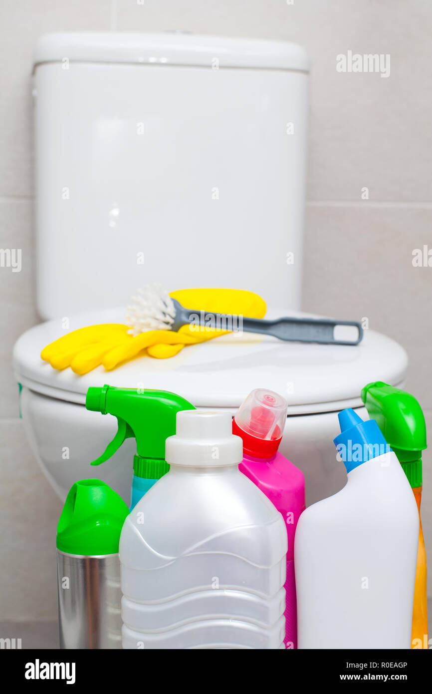 Colorful bathroom cleaning products and yellow rubber gloves, white ...
