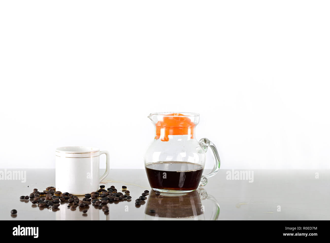 Coffee cup and coffee jug with coffee seed on a table against white ...