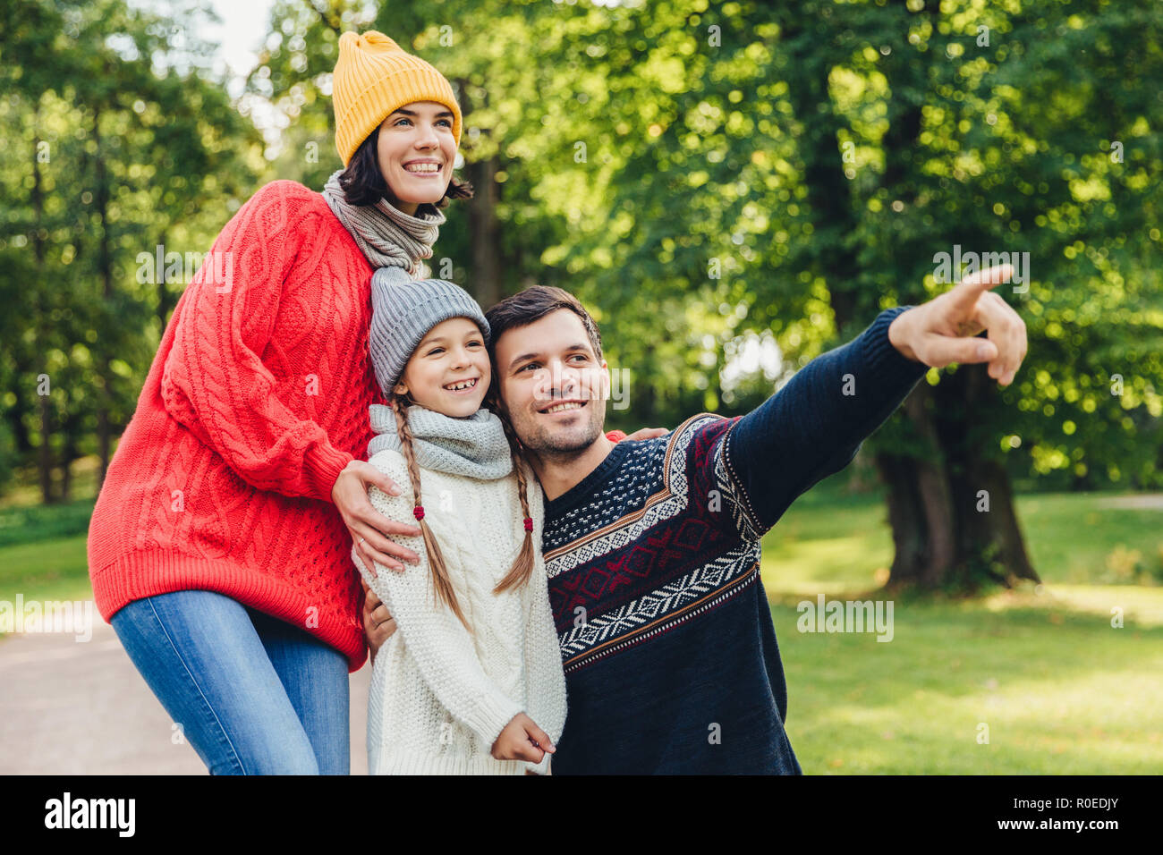 Three family members spend time together, look at beautiful lake in ...