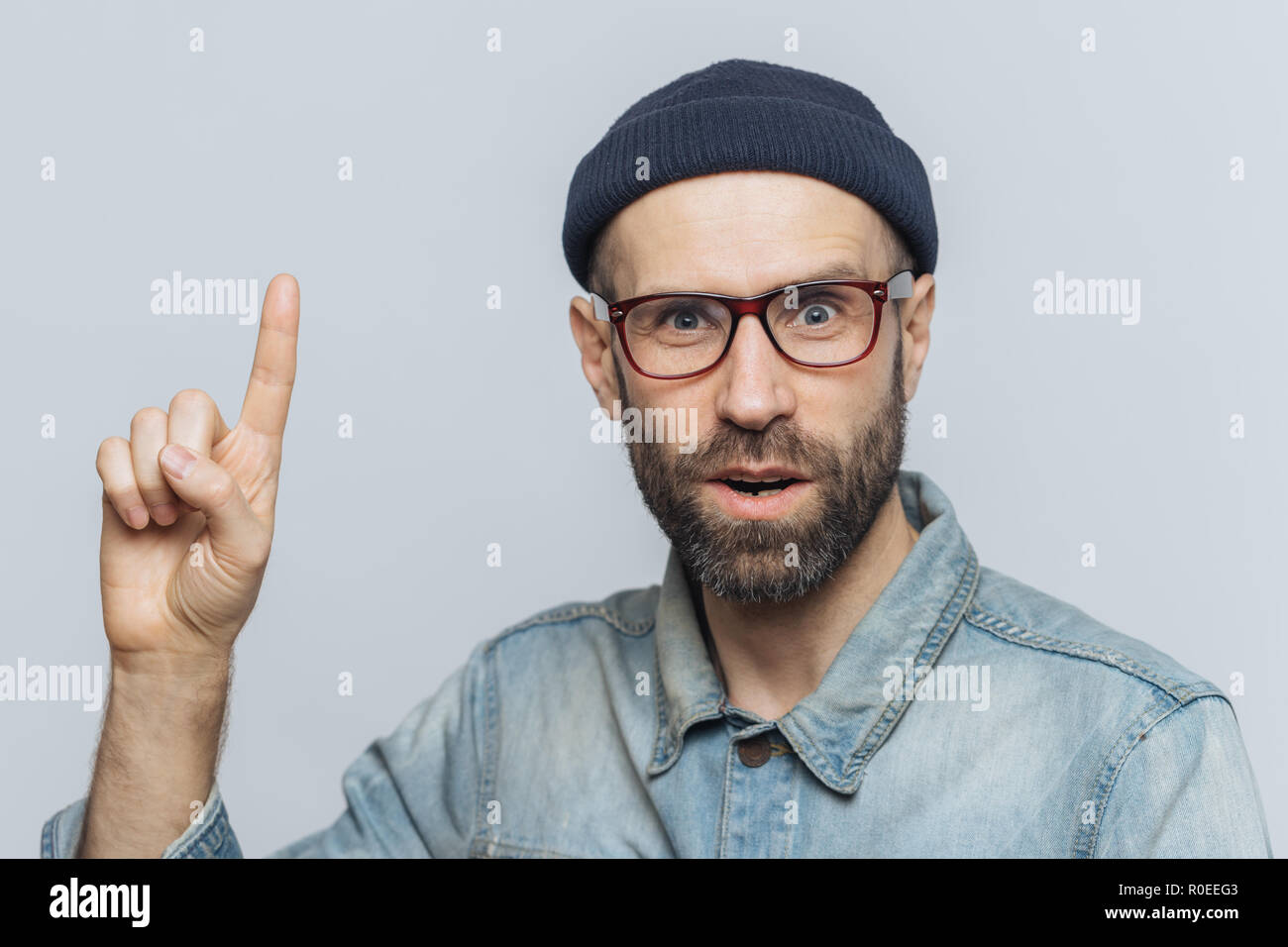 Amazed shocked man wears rectangular spectacles, looks with suprised ...