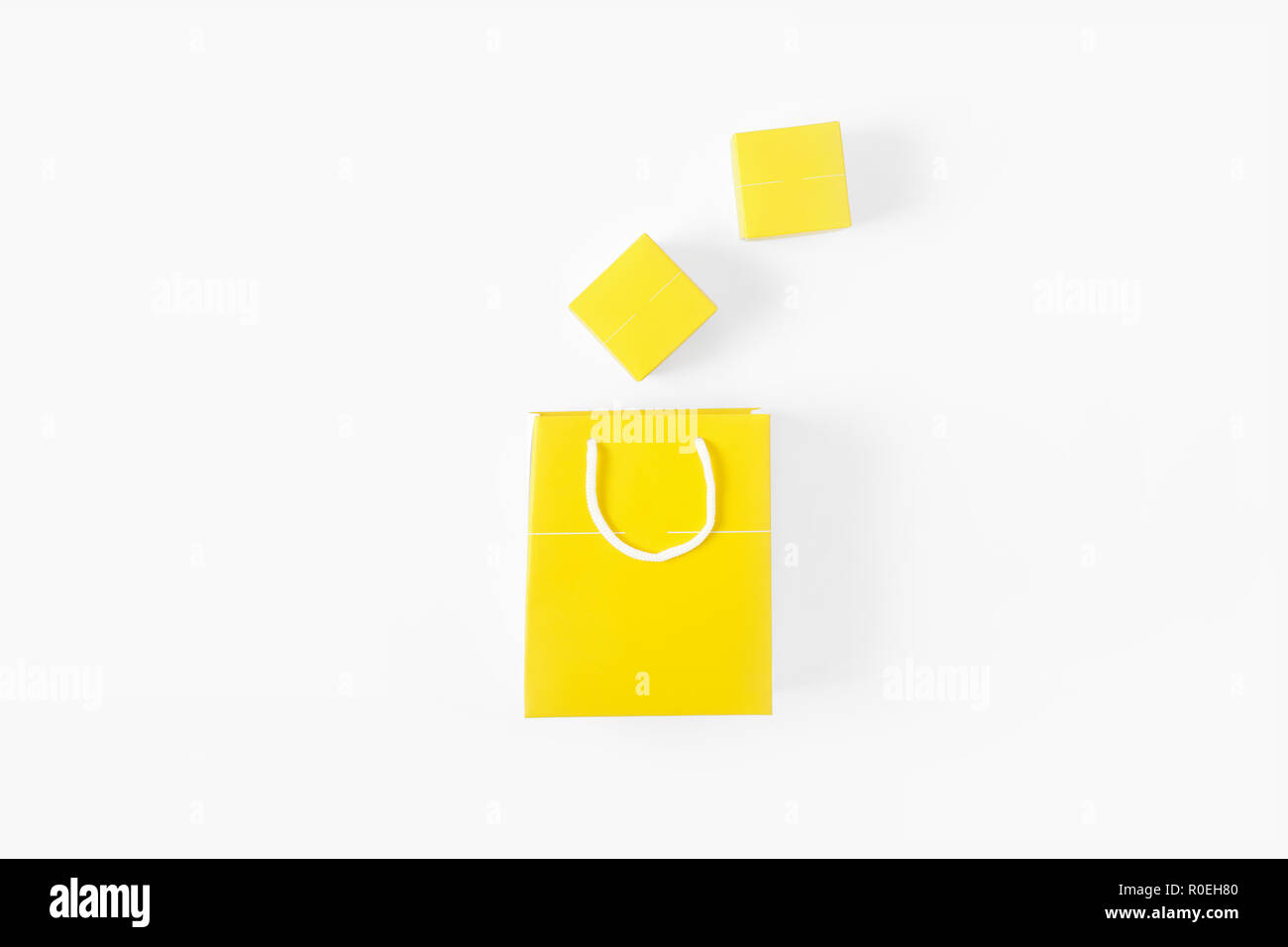 Yellow paper bags with small yellow gift boxes on white background top ...