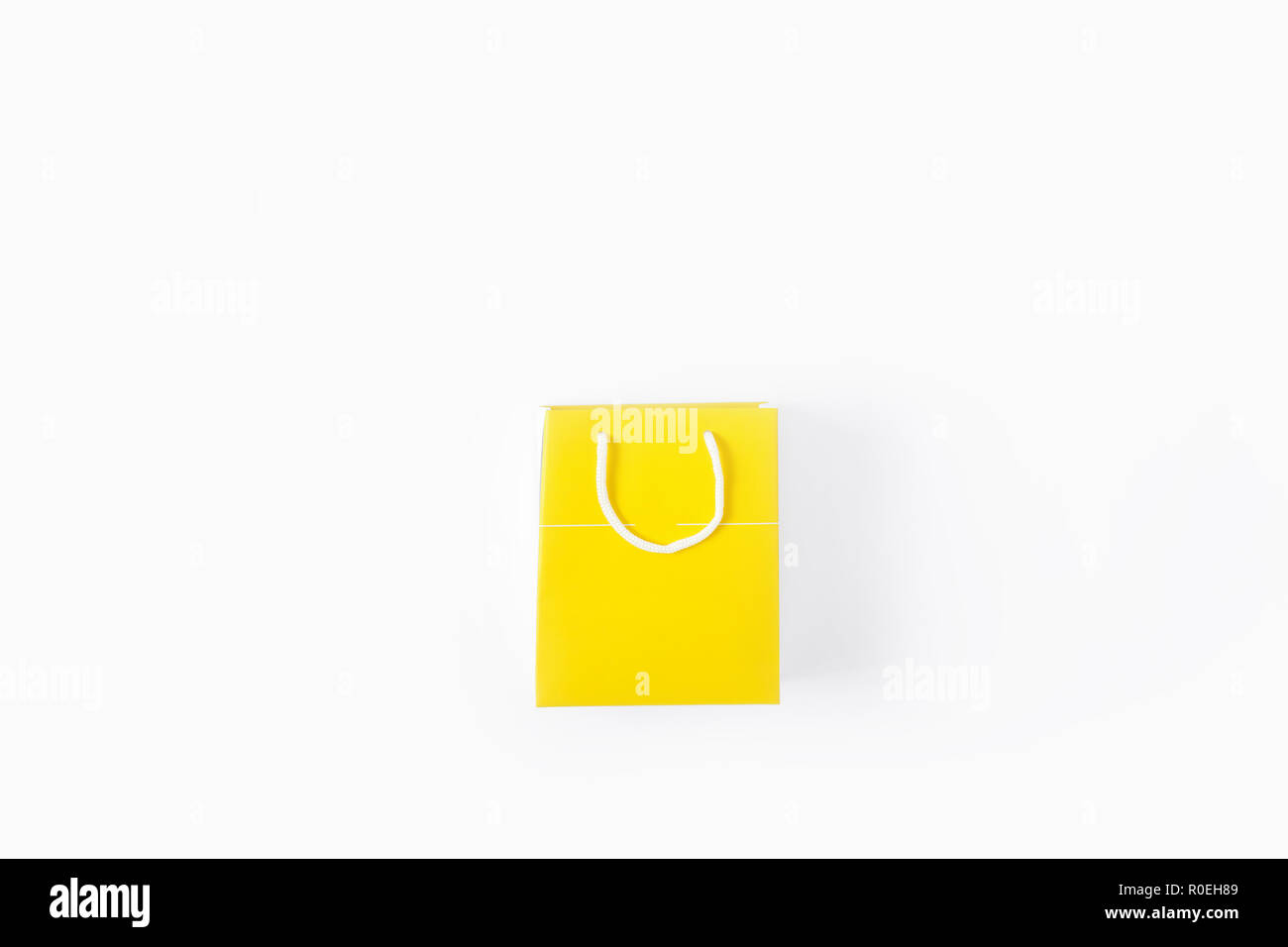 Yellow paper bag on white background top view flat lay Stock Photo - Alamy