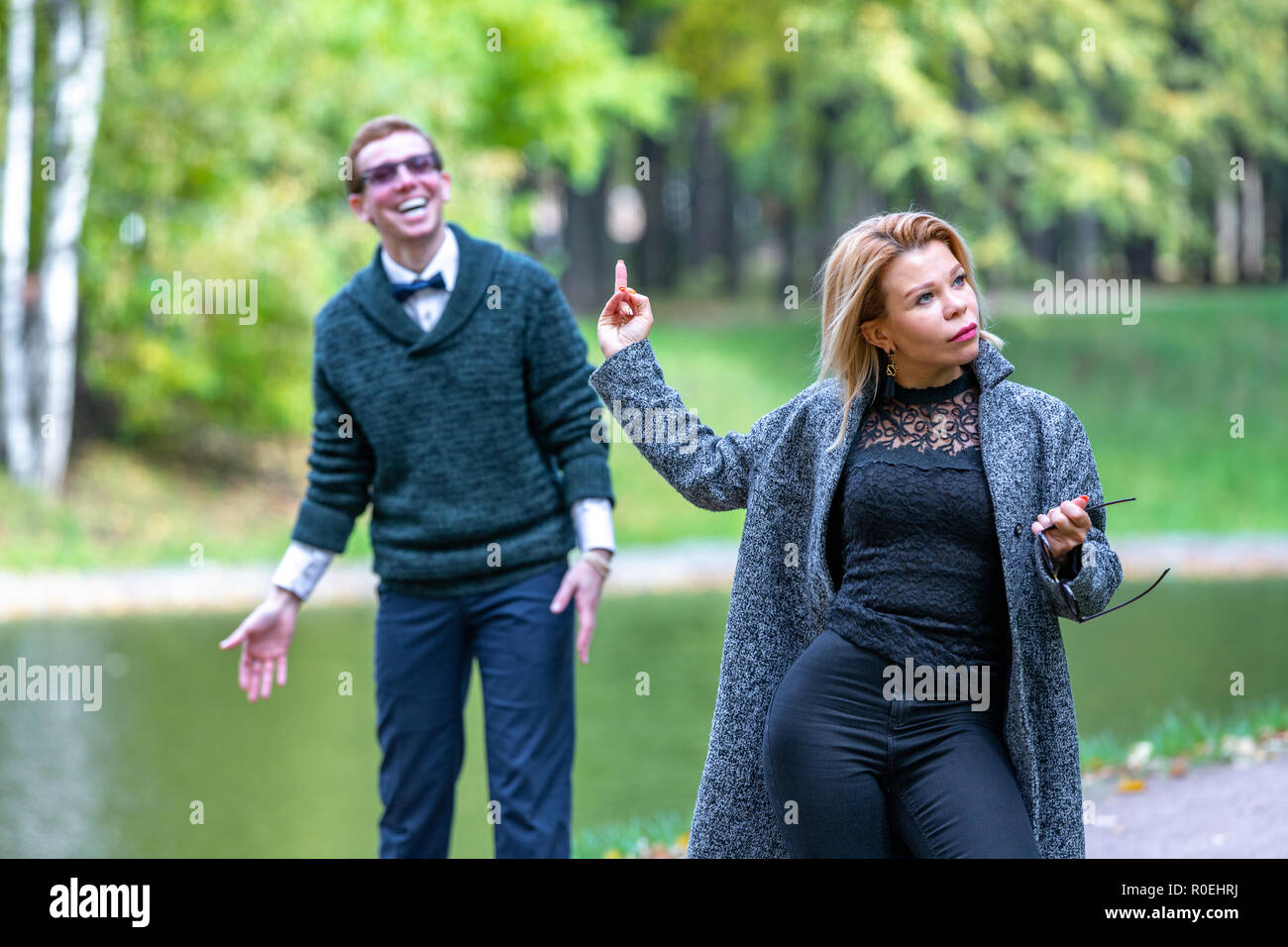 Couple talking seriously outdoors in a park with a green background ...