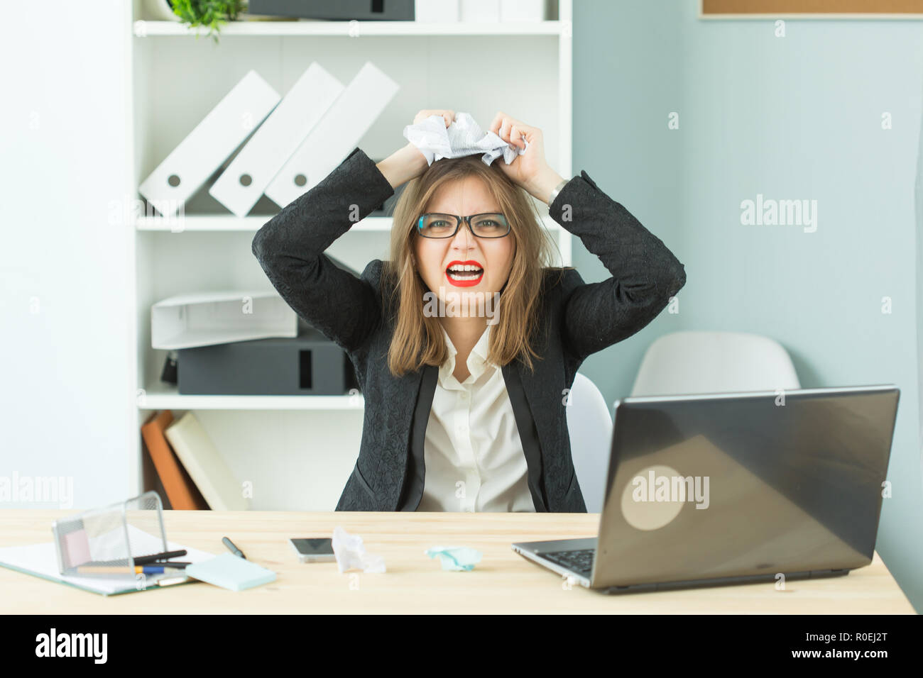 People, business and emotions concept - Angry woman sitting at desk in ...