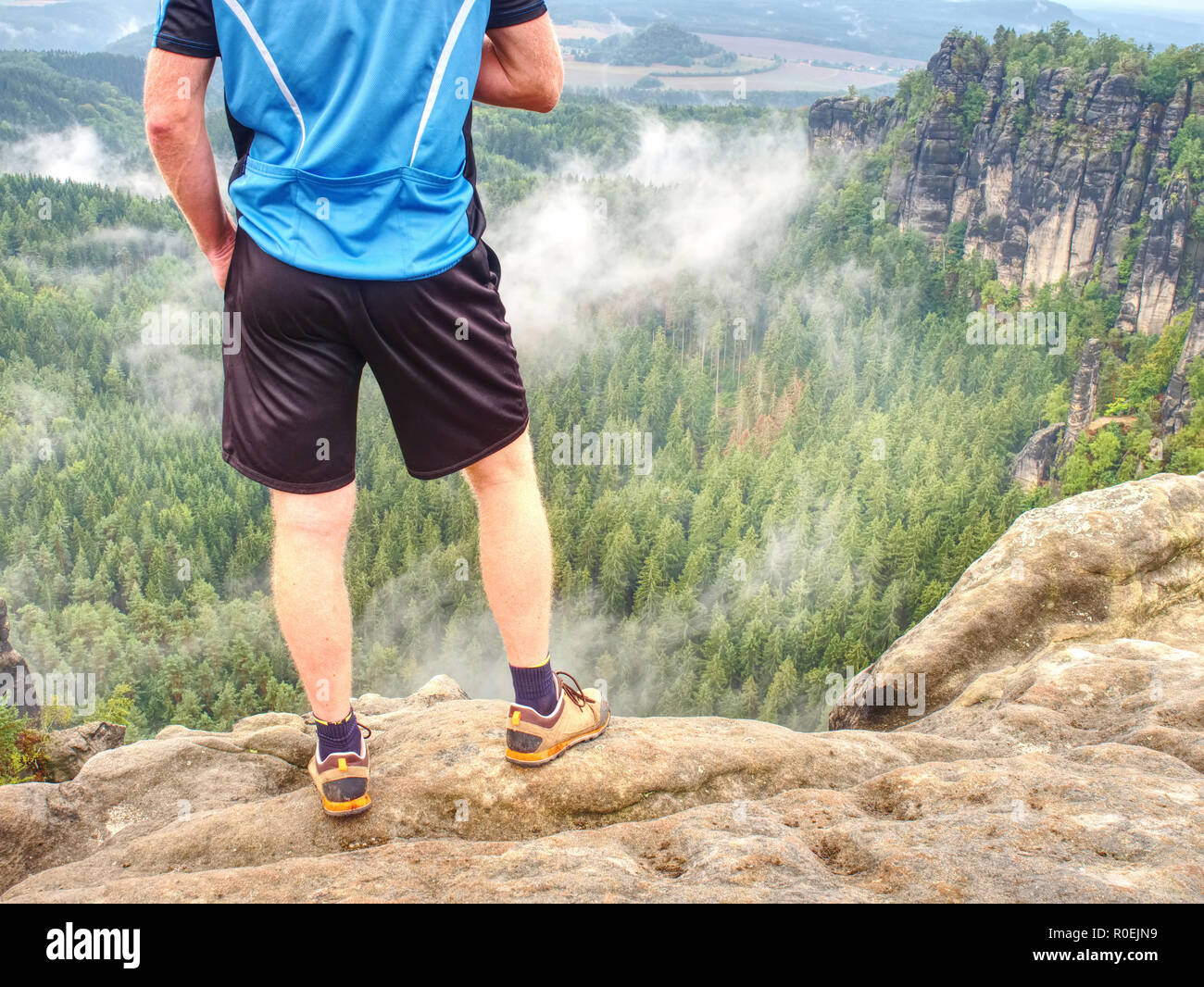 Hiker legs climbing on sunrise mountain peak rock. Slim legs of a ...