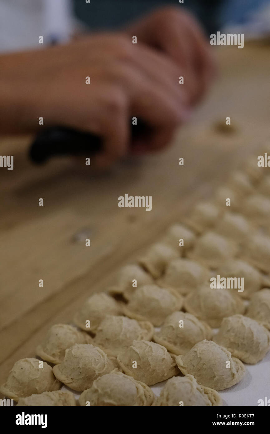 Close up of pasta making process. Woman makes orecchiette, ear shaped ...