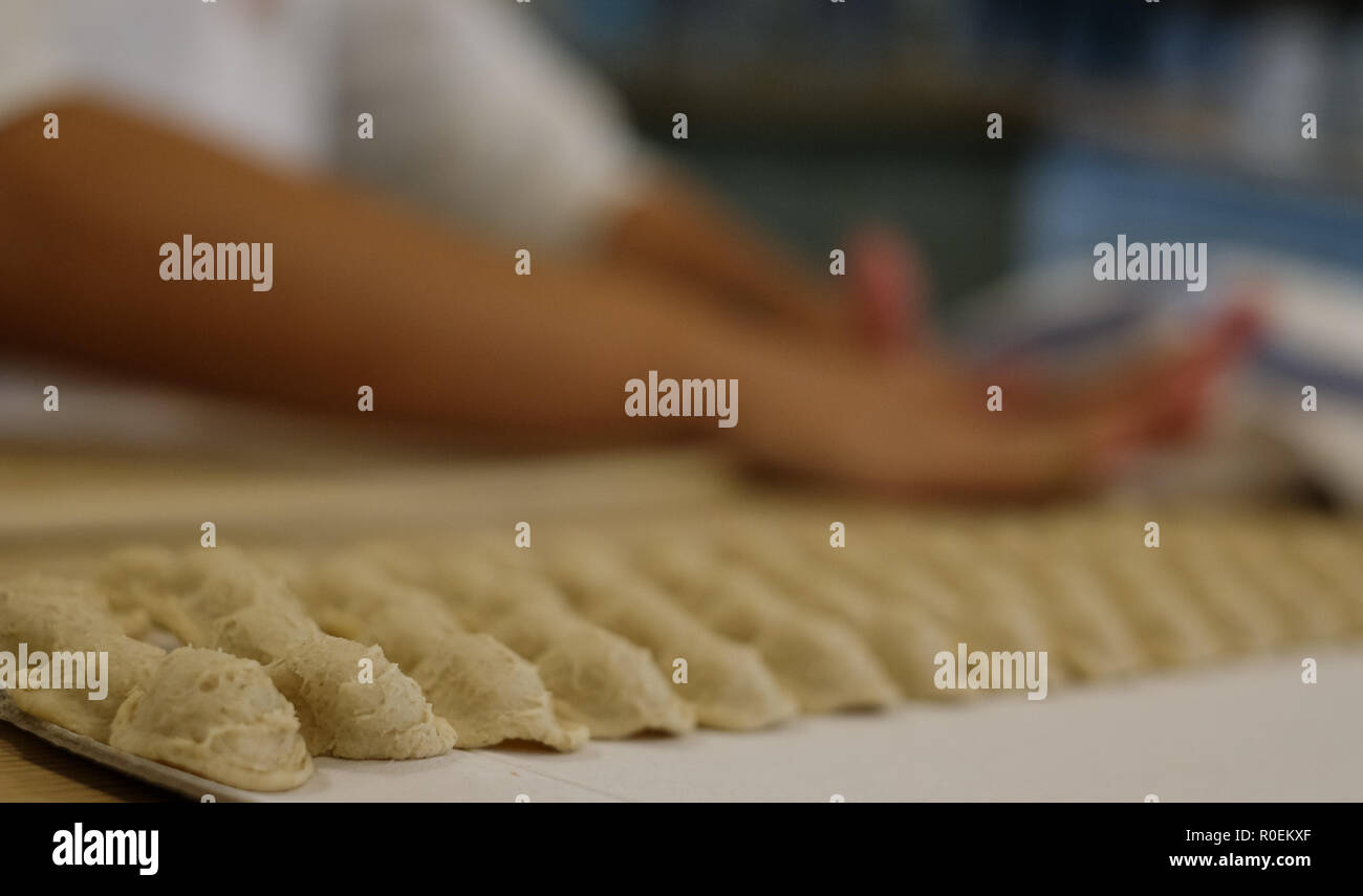 Close up of pasta making process. Woman makes orecchiette, ear shaped ...