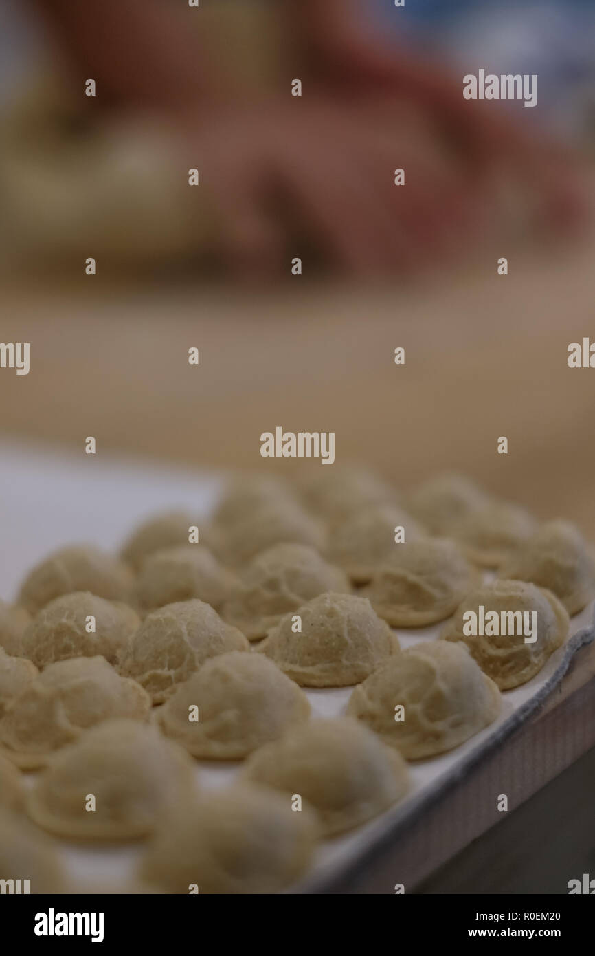 Close up of pasta making process. Woman makes orecchiette, ear shaped ...
