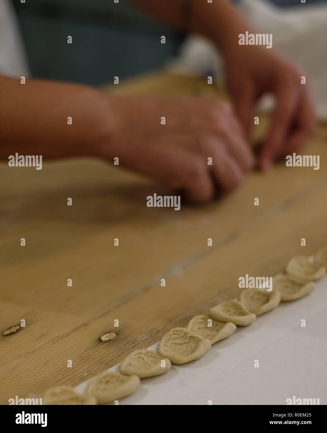 Close up of pasta making process. Woman makes orecchiette, ear shaped ...