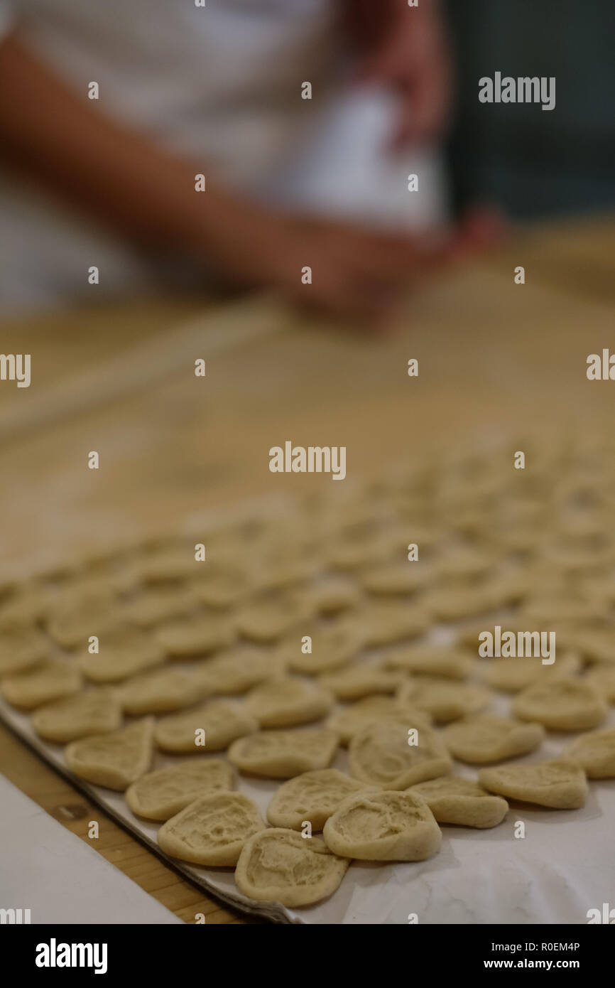 Close up of pasta making process. Woman makes orecchiette, ear shaped ...