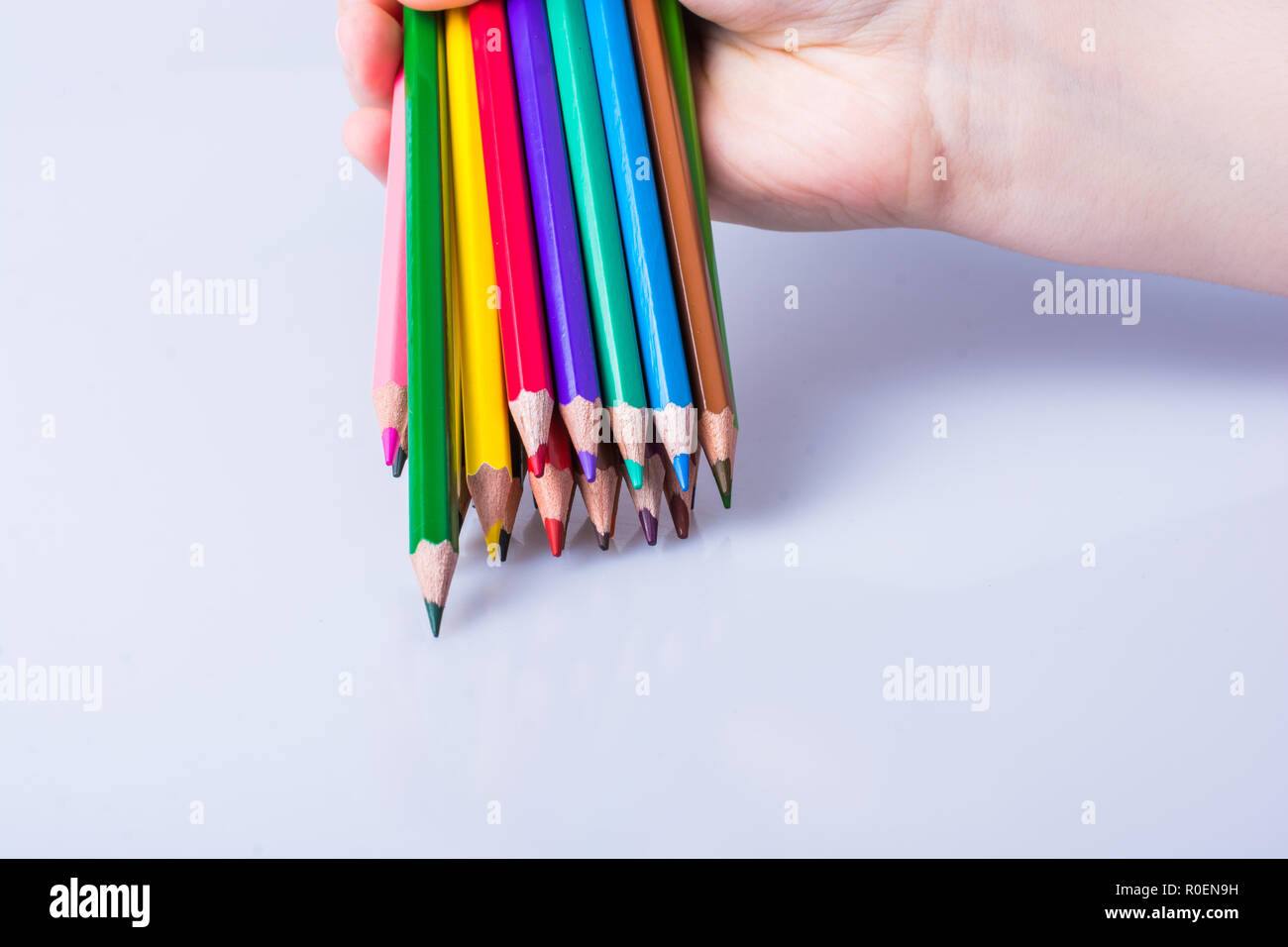 Hand holding color Pencils placed on a white background Stock Photo - Alamy