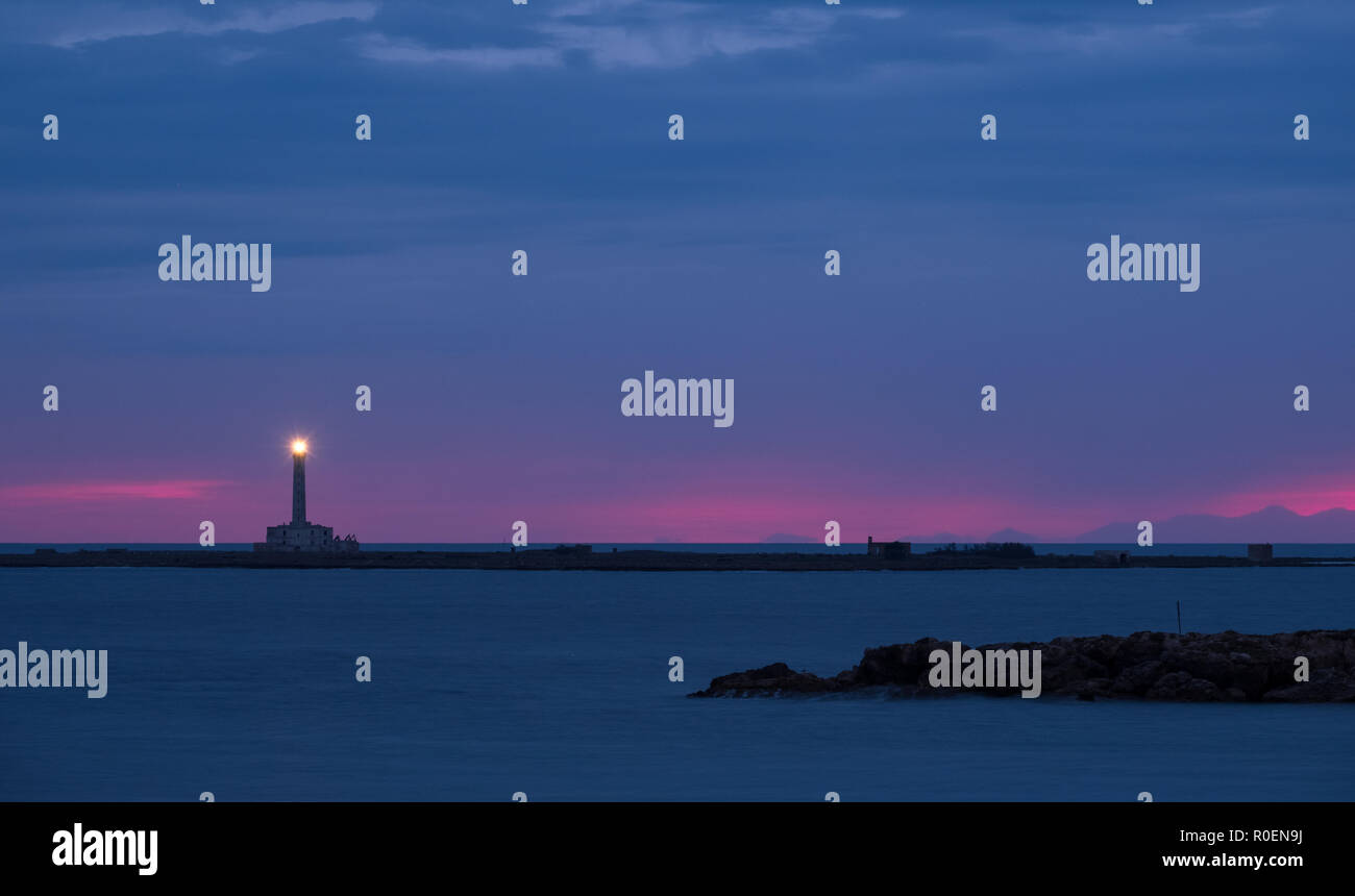 Lighthouse photographed against the sunset with pink sky, in Gallipoli ...