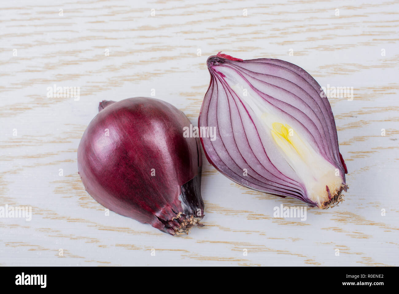 Red onion bulb cut in half on a certain background Stock Photo - Alamy