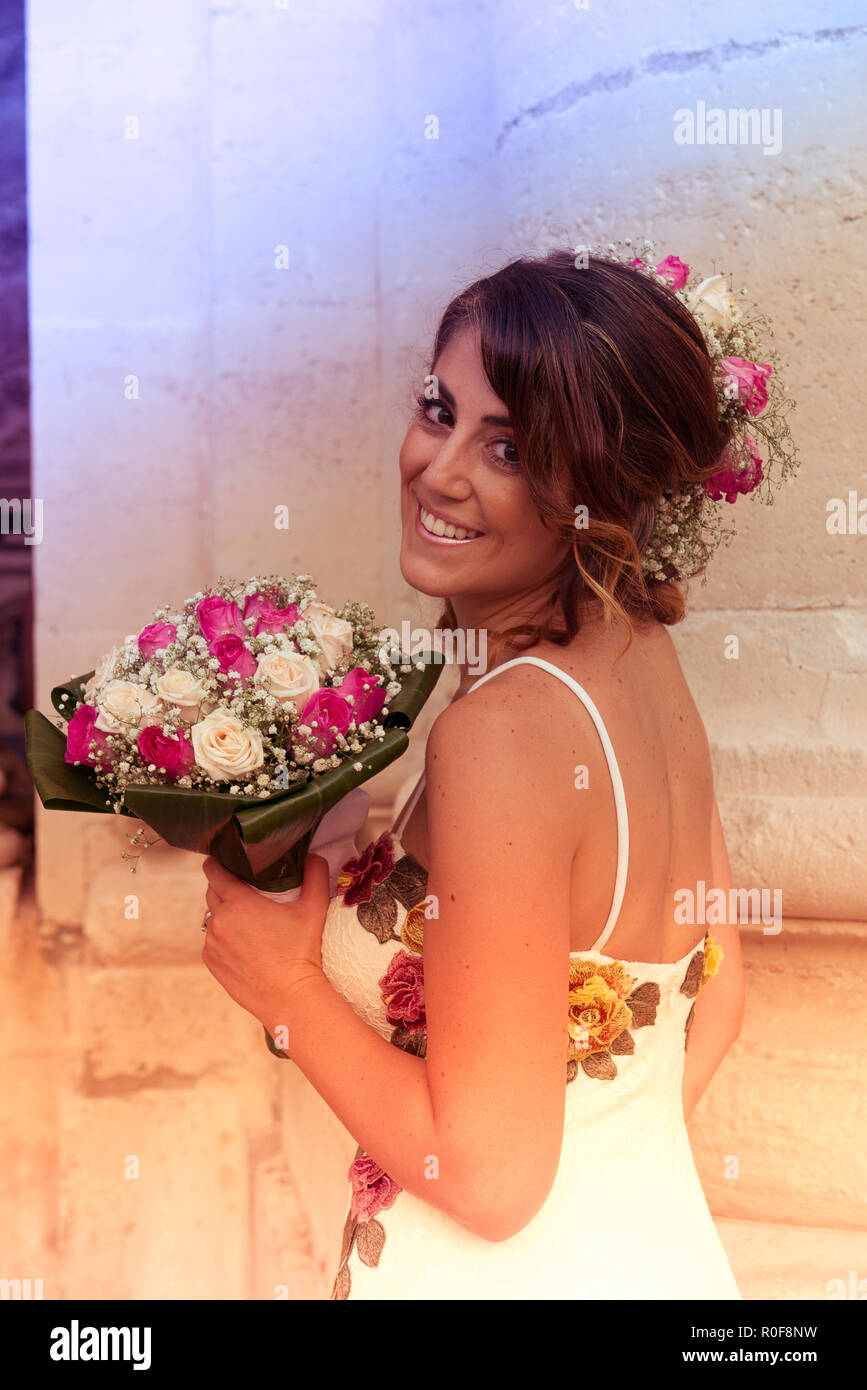 A girl, on the day of her wedding, white dressed, is posing . On the ...