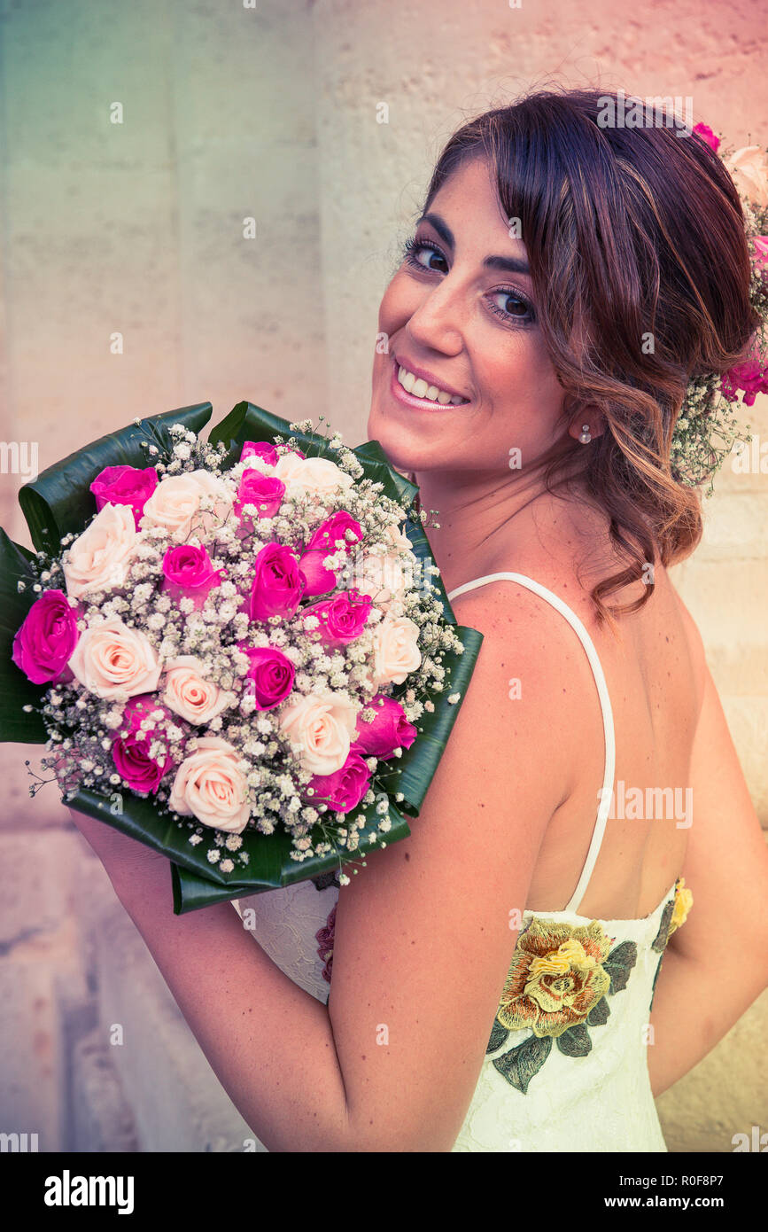 A girl, on the day of her wedding, white dressed, is posing . On the ...