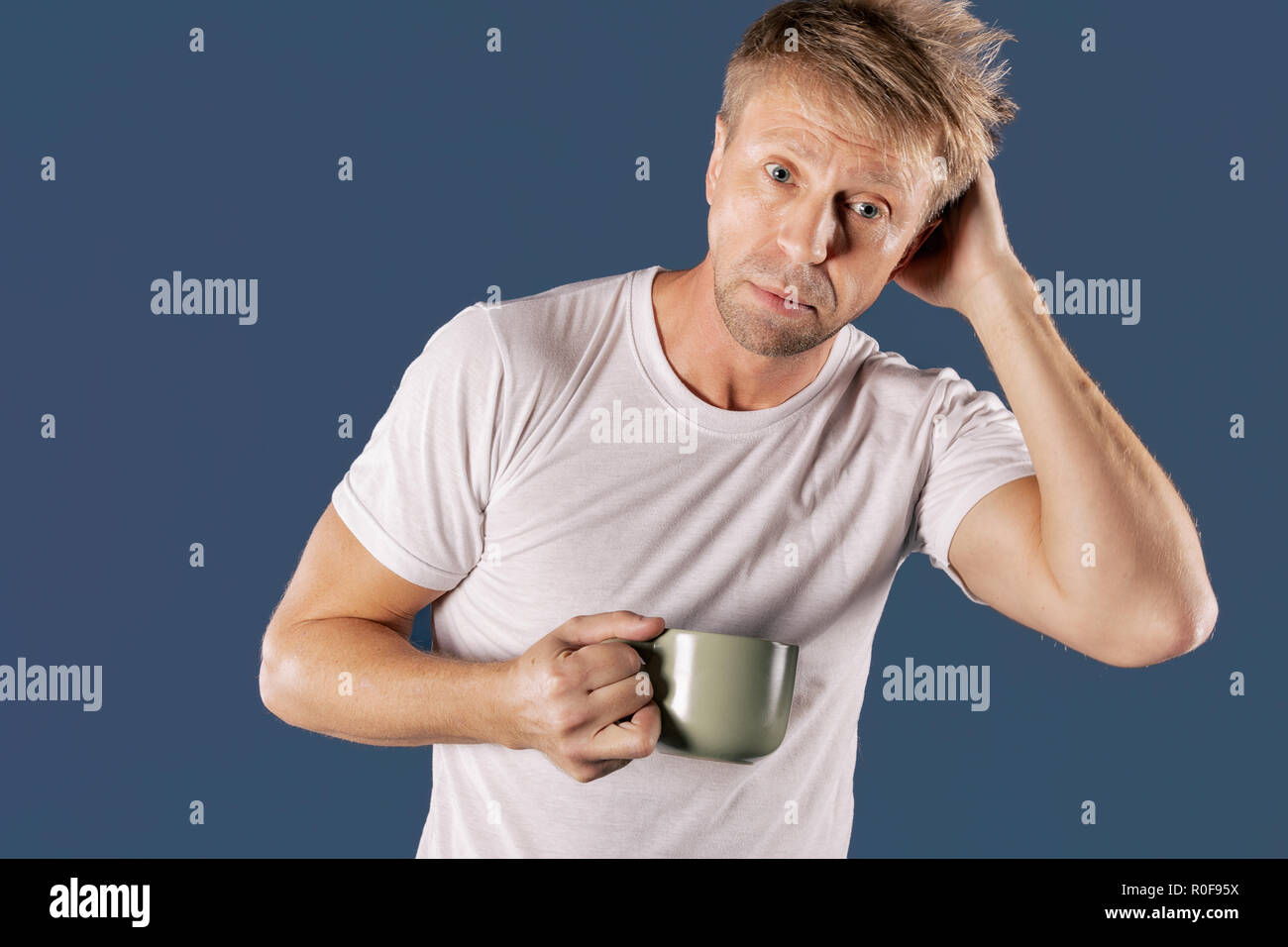 Sleepy man with a mug of coffee Stock Photo - Alamy