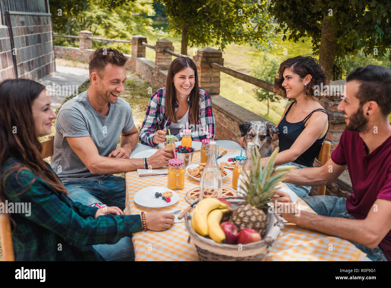 Happy cheerful group of friends having breakfast in a farmhouse - Young ...