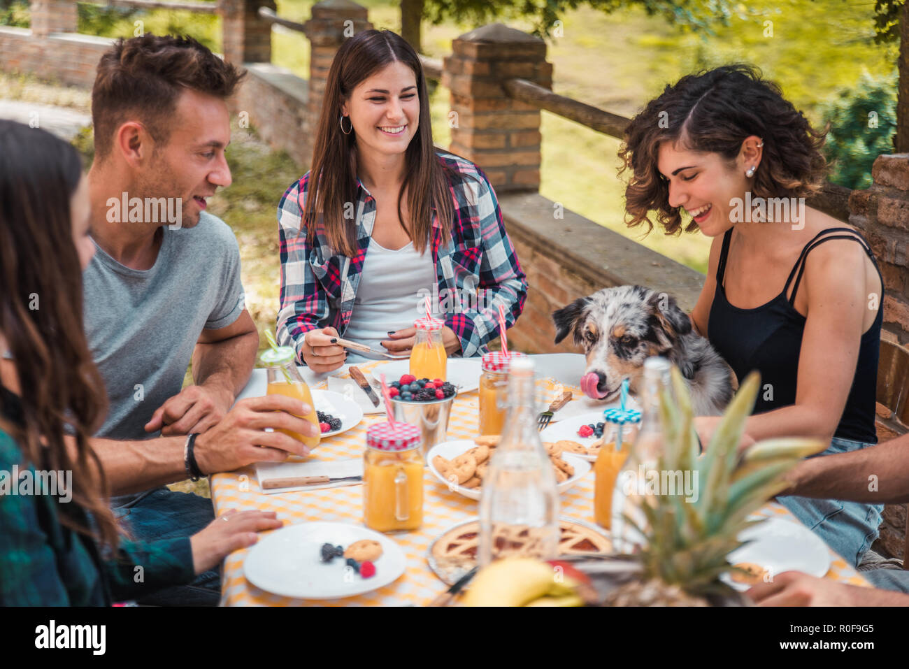 Happy cheerful group of friends having breakfast in a farmhouse - Young ...