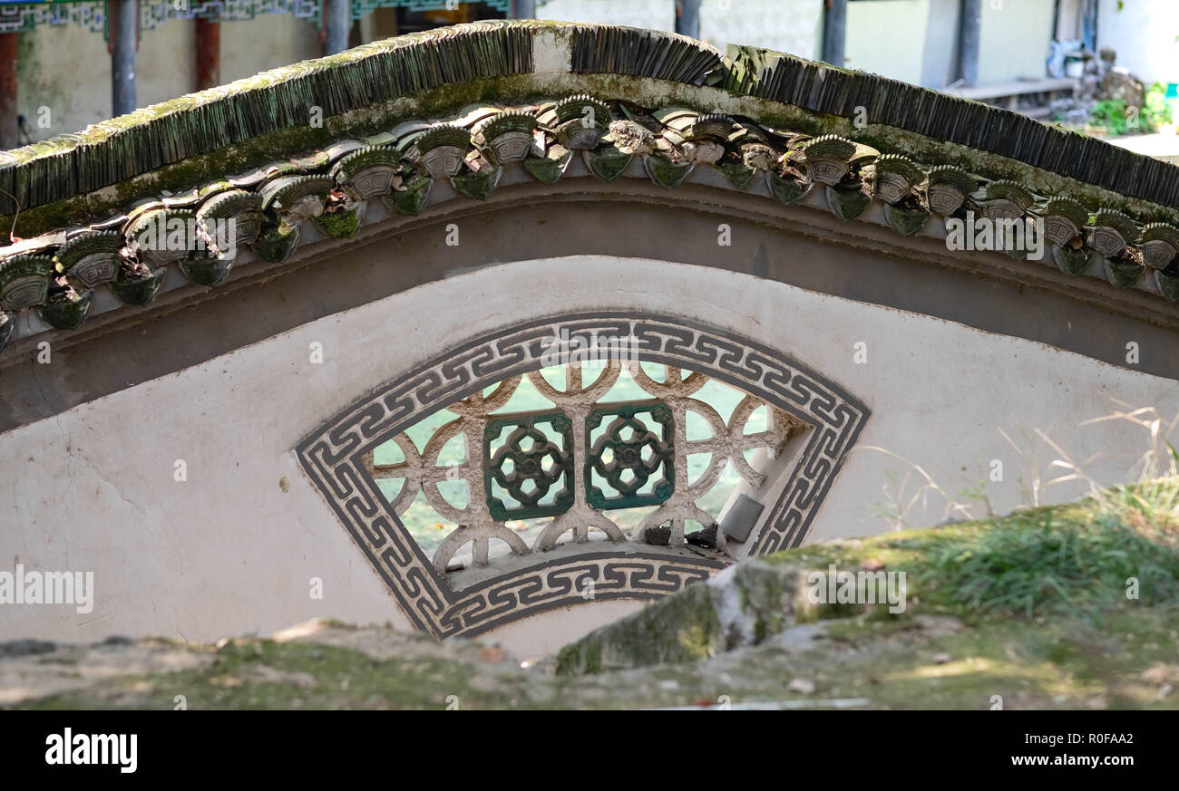 Traditional Chinese style carved ciement window frame on a white wall ...