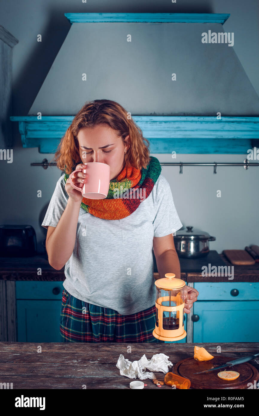 Sick woman drink tea in the kitchen Stock Photo - Alamy