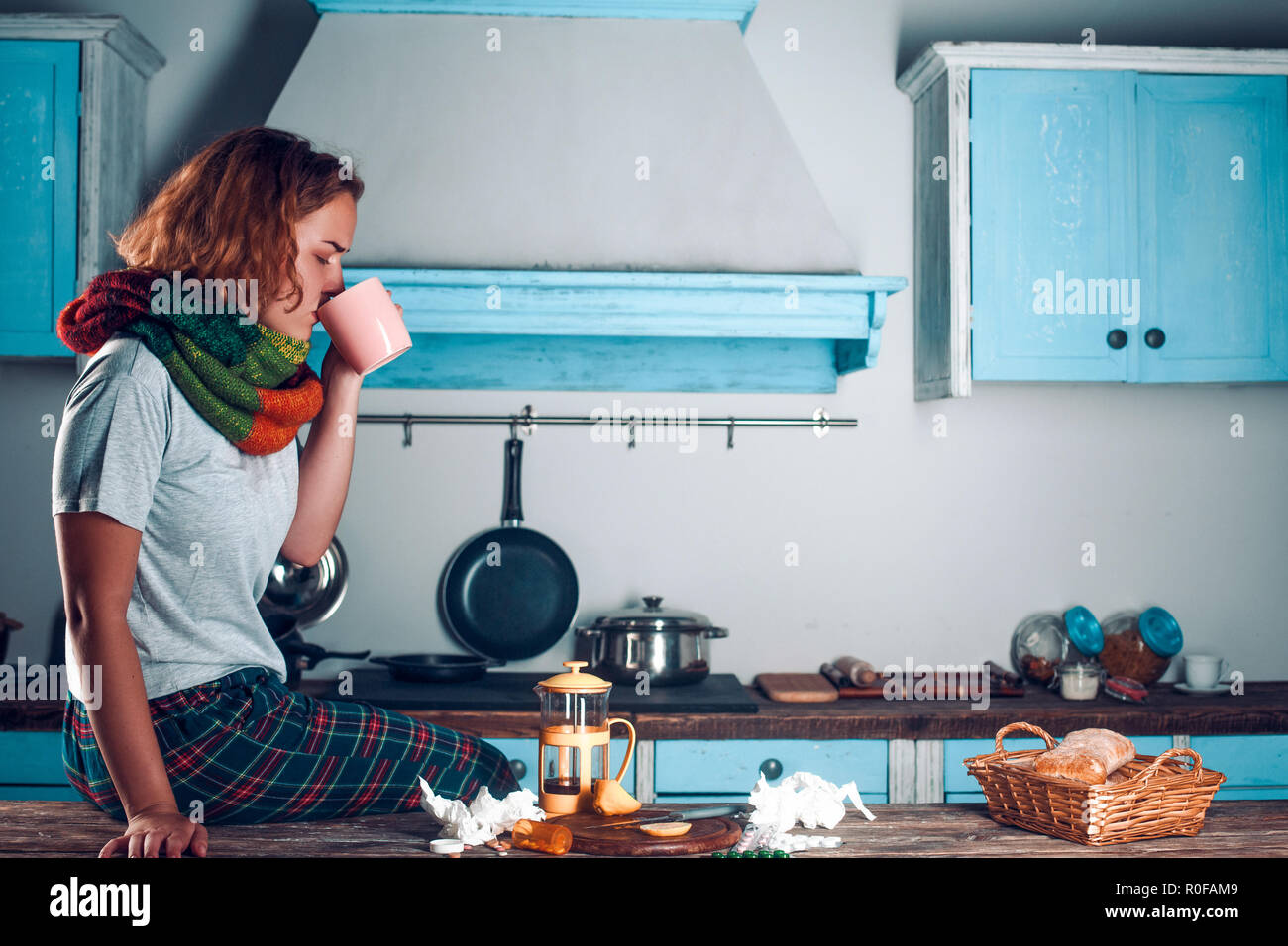 Sick woman drink tea in the kitchen Stock Photo - Alamy