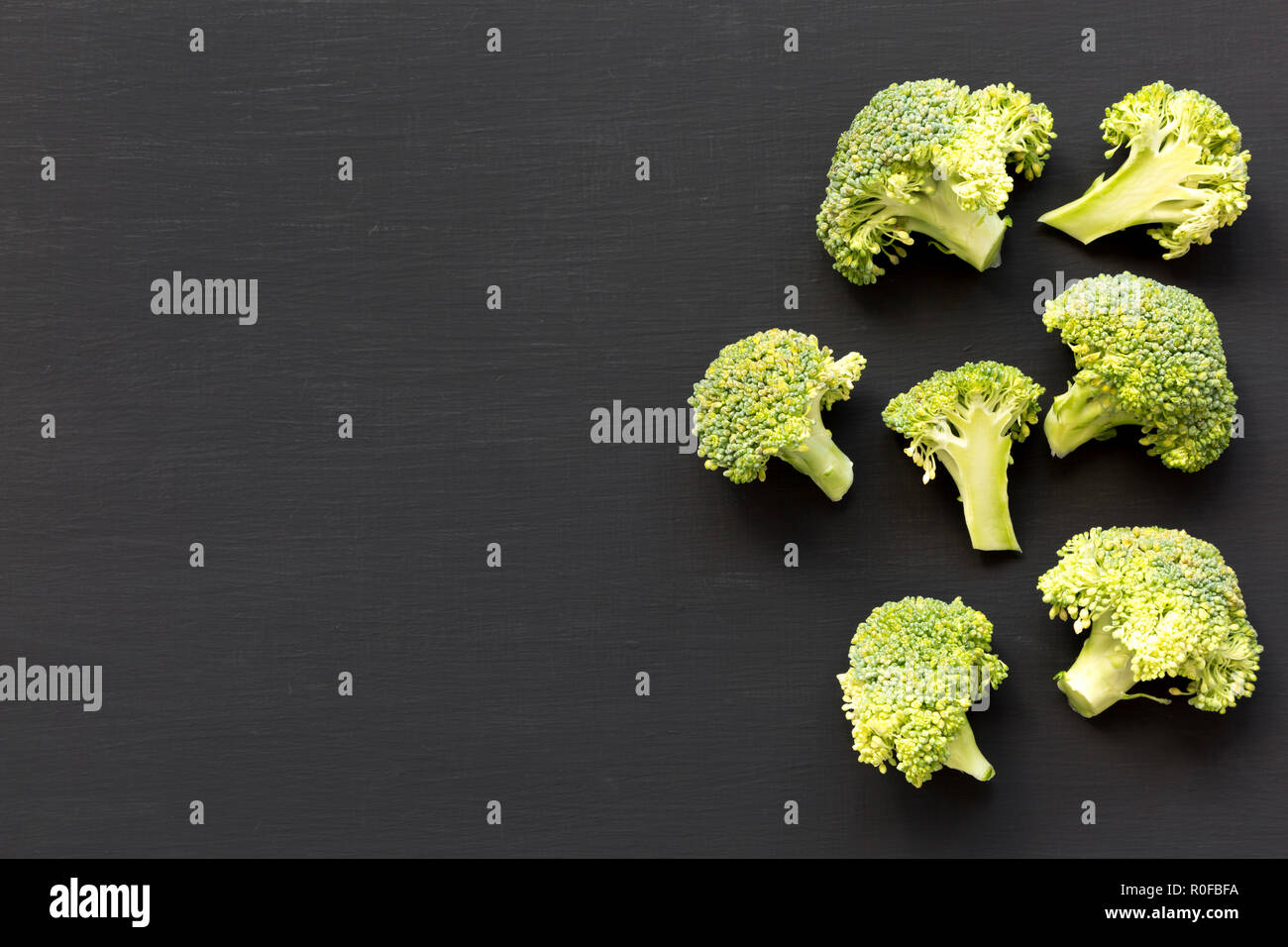 Raw broccoli on black background, overhead view. From above, flat lay ...